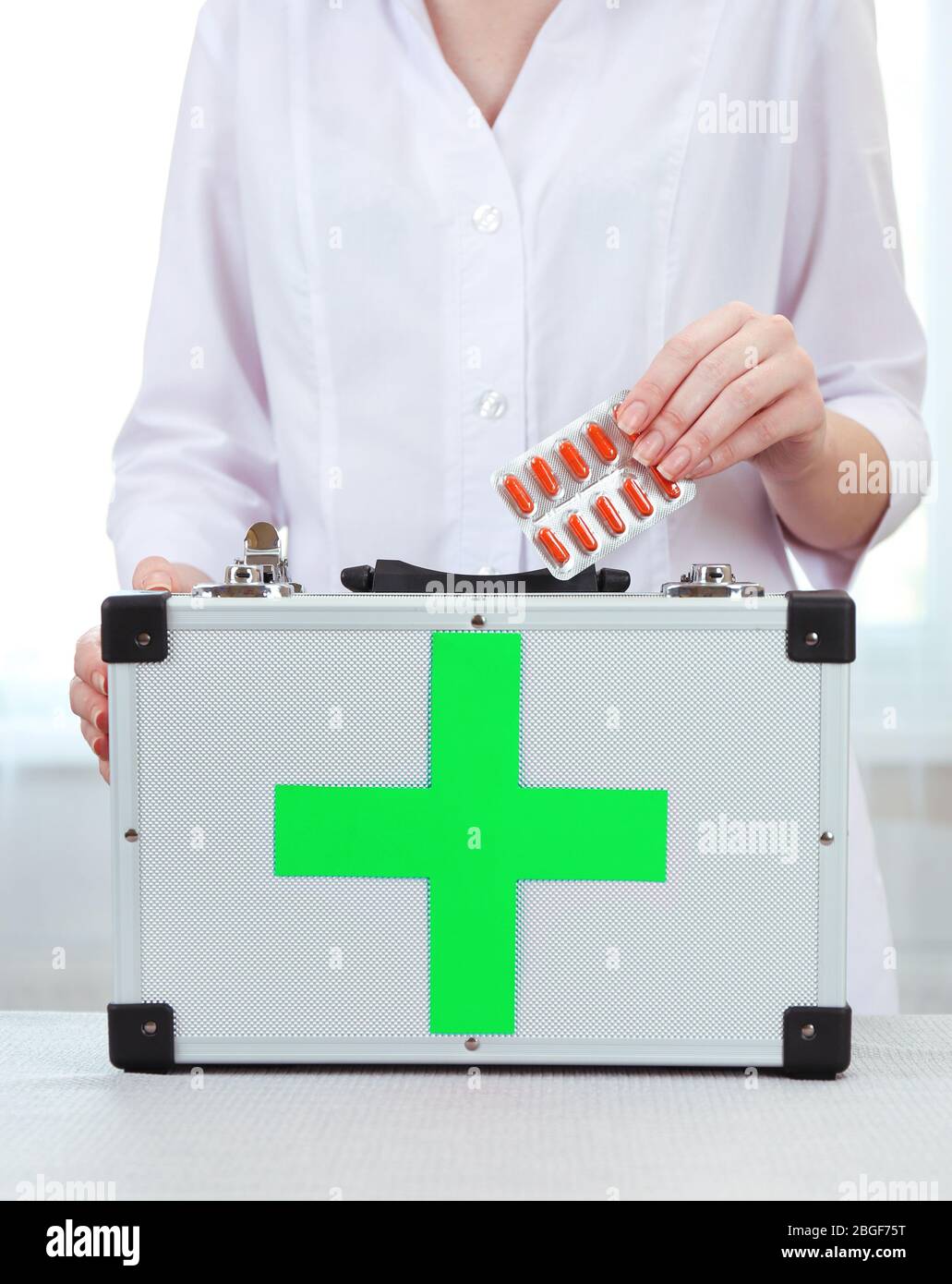 Nurse holding first aid kit in room Stock Photo - Alamy