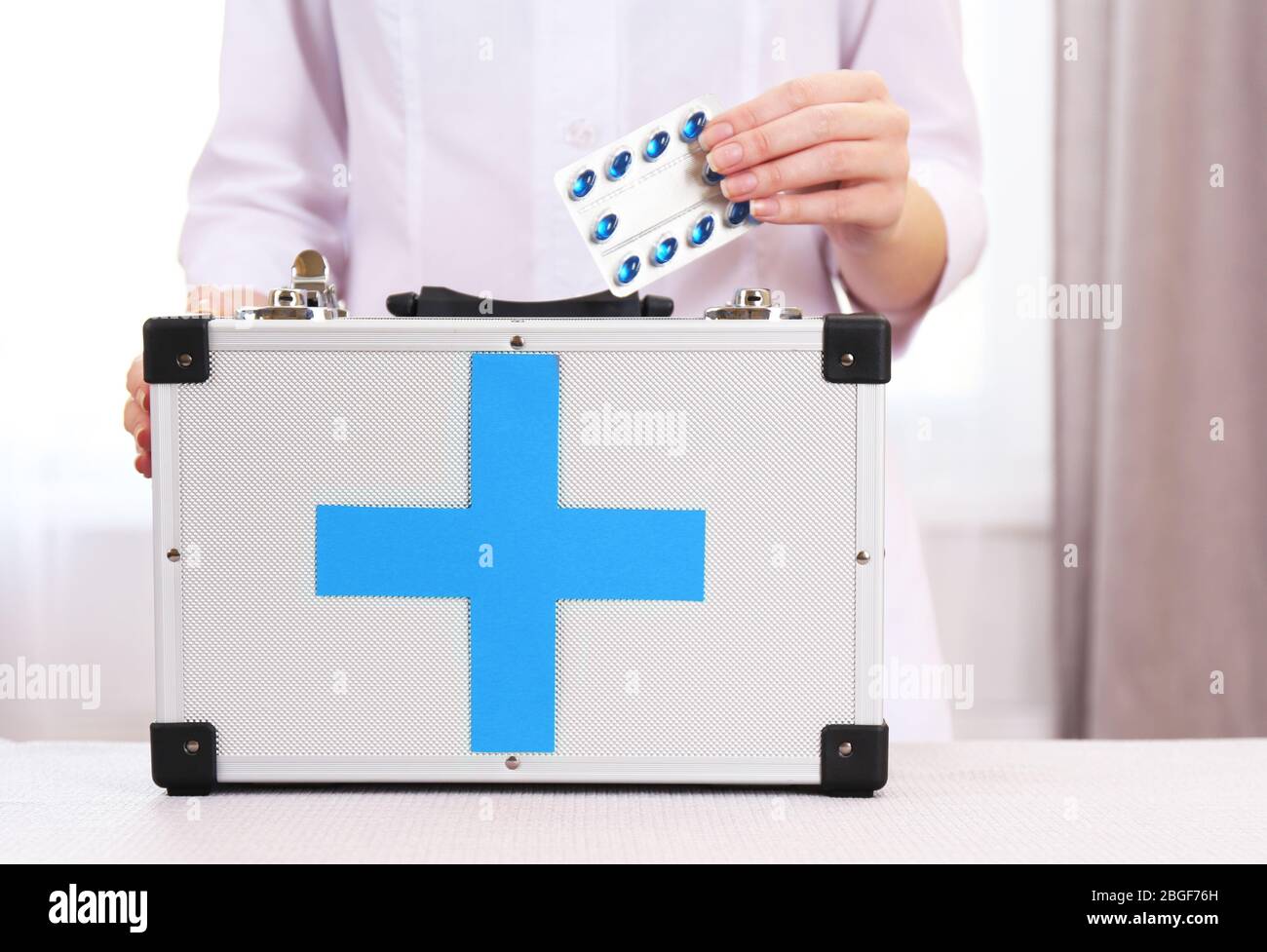 Nurse holding first aid kit in room Stock Photo - Alamy