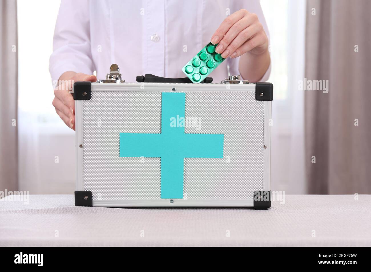 Nurse holding first aid kit in room Stock Photo - Alamy