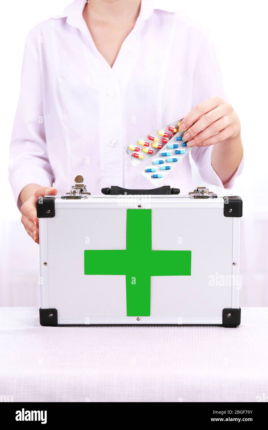 Nurse holding first aid kit in room Stock Photo - Alamy