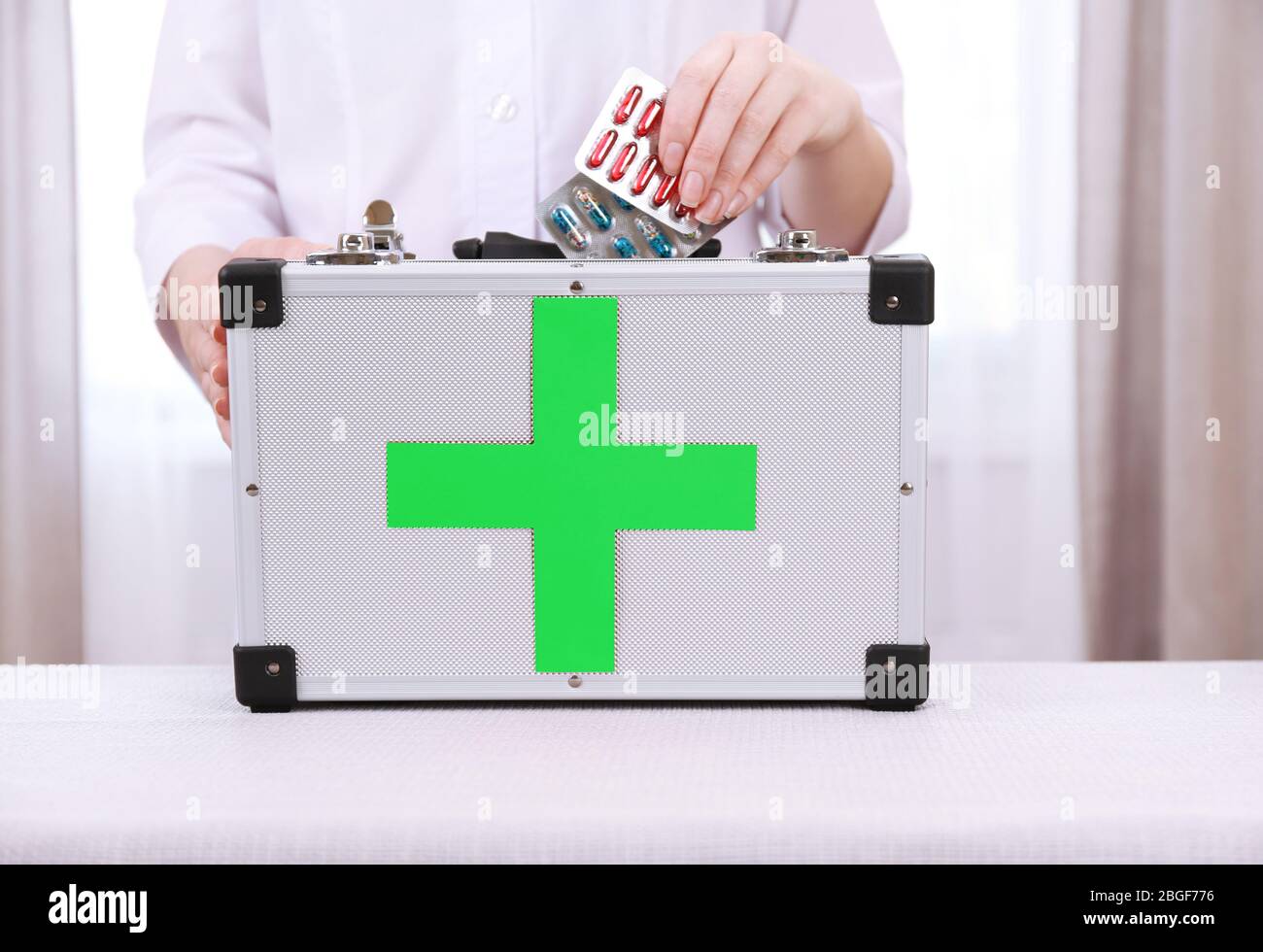 Nurse holding first aid kit in room Stock Photo - Alamy