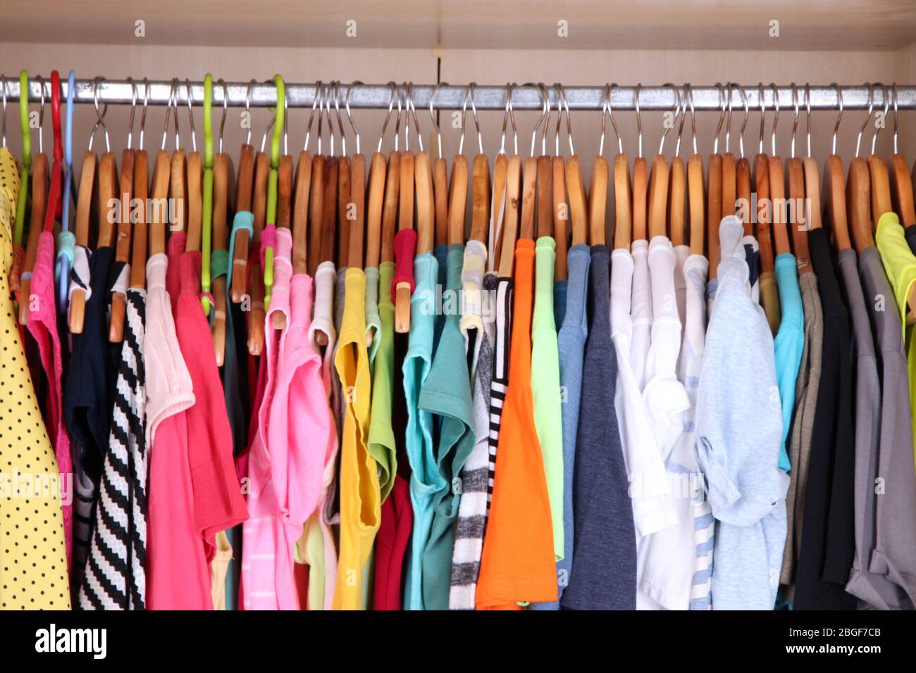 Colorful clothes hanging in wardrobe Stock Photo - Alamy