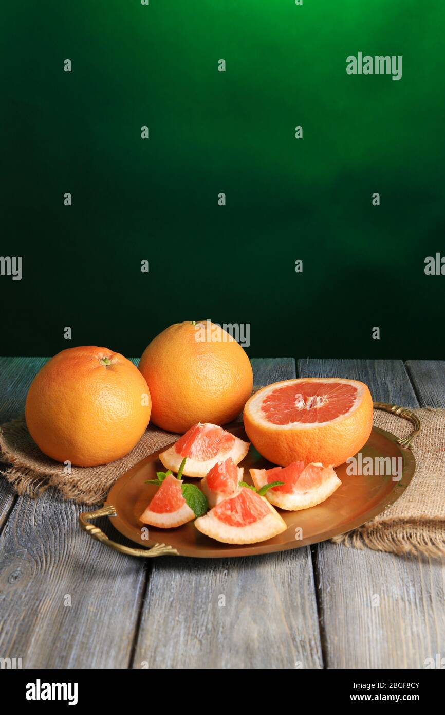 Ripe grapefruits on wooden board, on dark color background Stock Photo ...