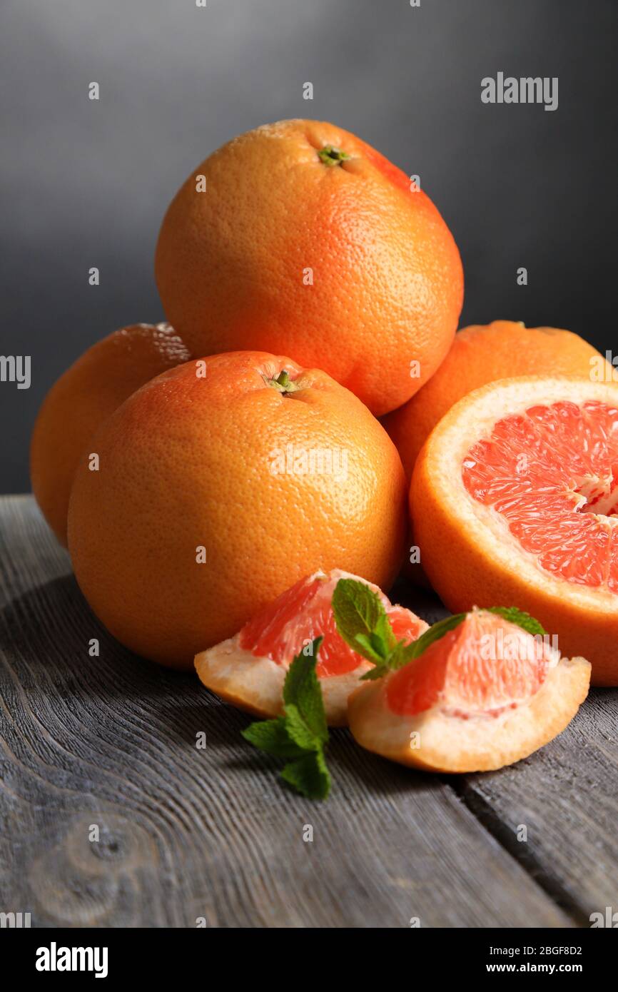Ripe grapefruits on wooden board, on dark color background Stock Photo ...