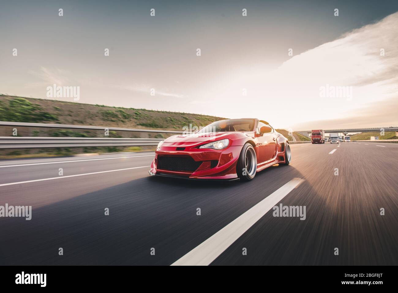 Red racing car on the highway in a sunny day,eco drive Stock Photo - Alamy