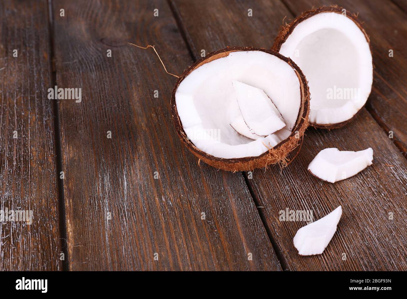 Broken coconut on wooden background Stock Photo - Alamy