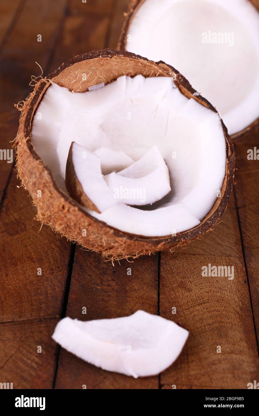 Broken coconut on wooden background Stock Photo - Alamy