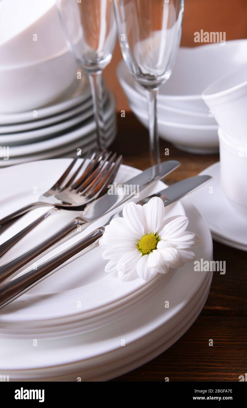 Set of white dishes on table on brown background Stock Photo - Alamy