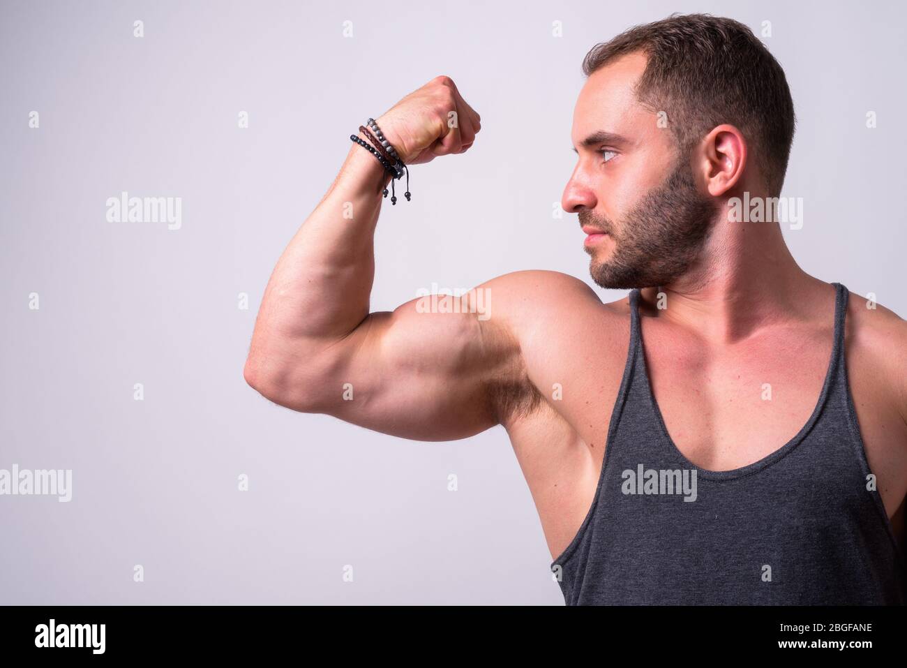 Portrait of muscular bearded man flexing bicep Stock Photo - Alamy