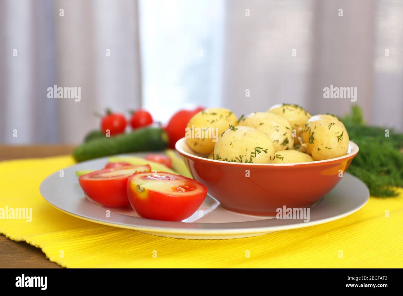 Young boiled potatoes on table on window background Stock Photo - Alamy