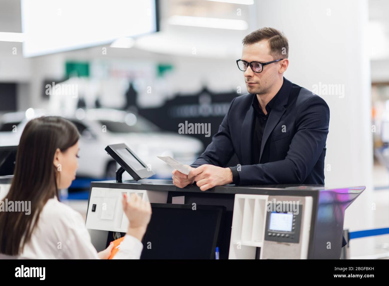 Staff At Airport Check In Desk Handing Ticket To Businessman Stock ...