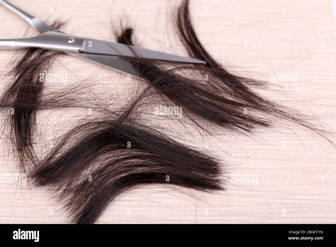 Cut hair and scissors on tile background Stock Photo - Alamy