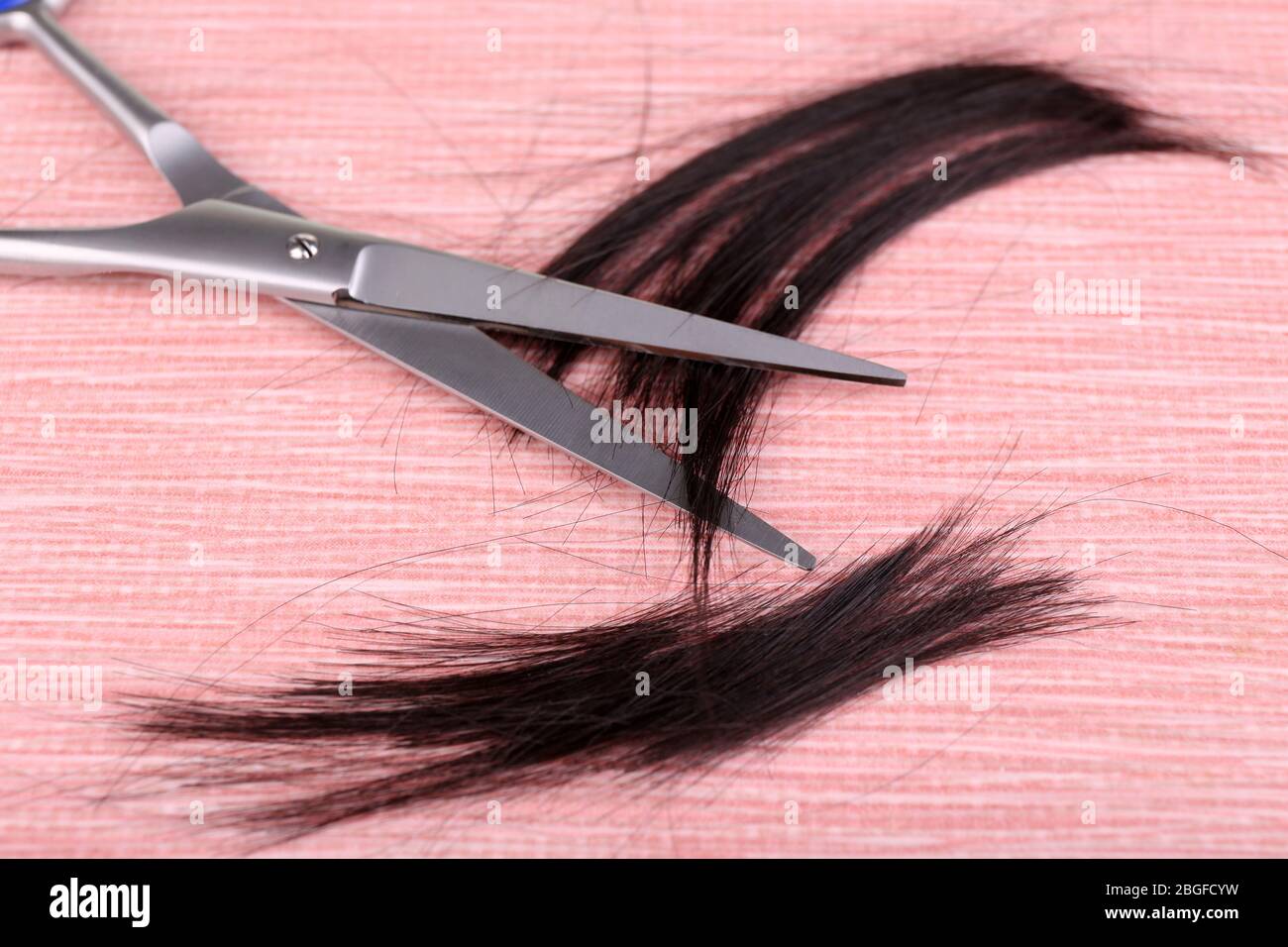 Cut hair and scissors on tile background Stock Photo - Alamy