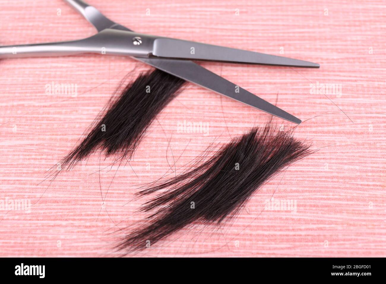 Cut hair and scissors on tile background Stock Photo - Alamy