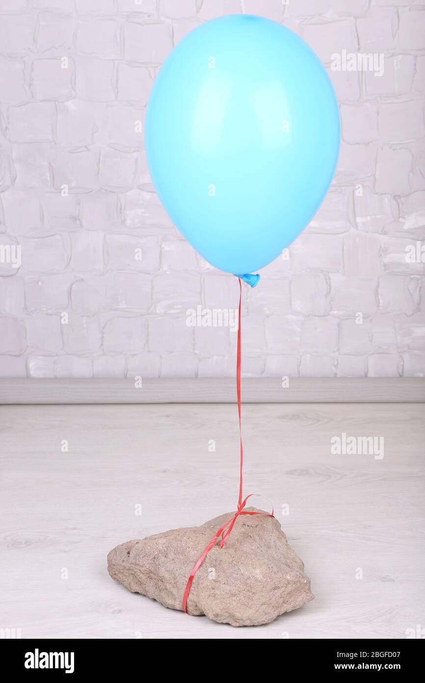 Color balloon with stone on grey wall background Stock Photo - Alamy