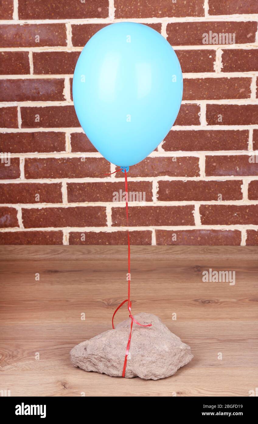 Color balloon with stone on brick wall background Stock Photo - Alamy