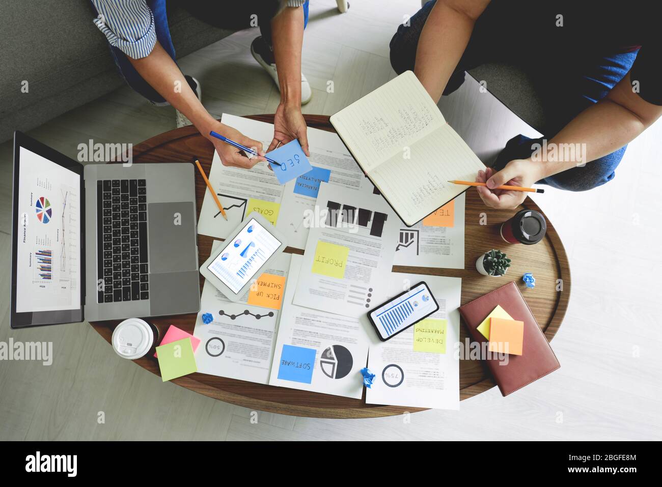 Business people writing on sticky notes for colleagues thinking ...