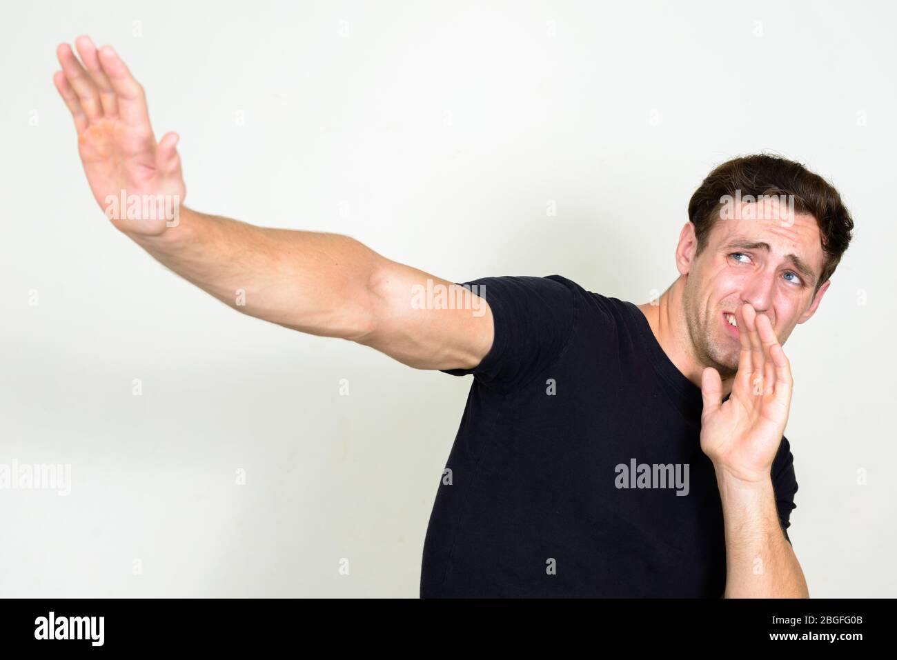 Portrait of stressed young man looking scared with arms raised Stock ...