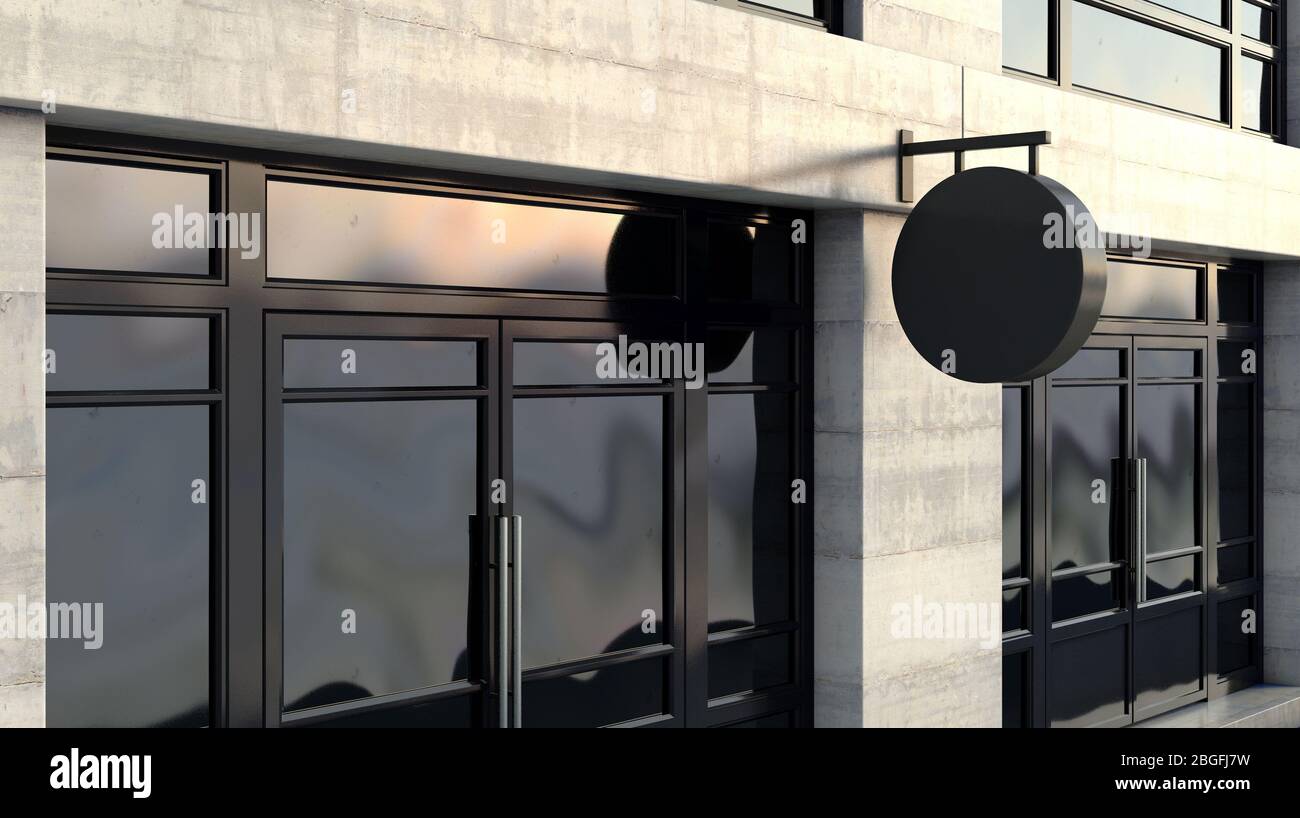 A round black sign mounted outside a generic unbranded shop facade on ...