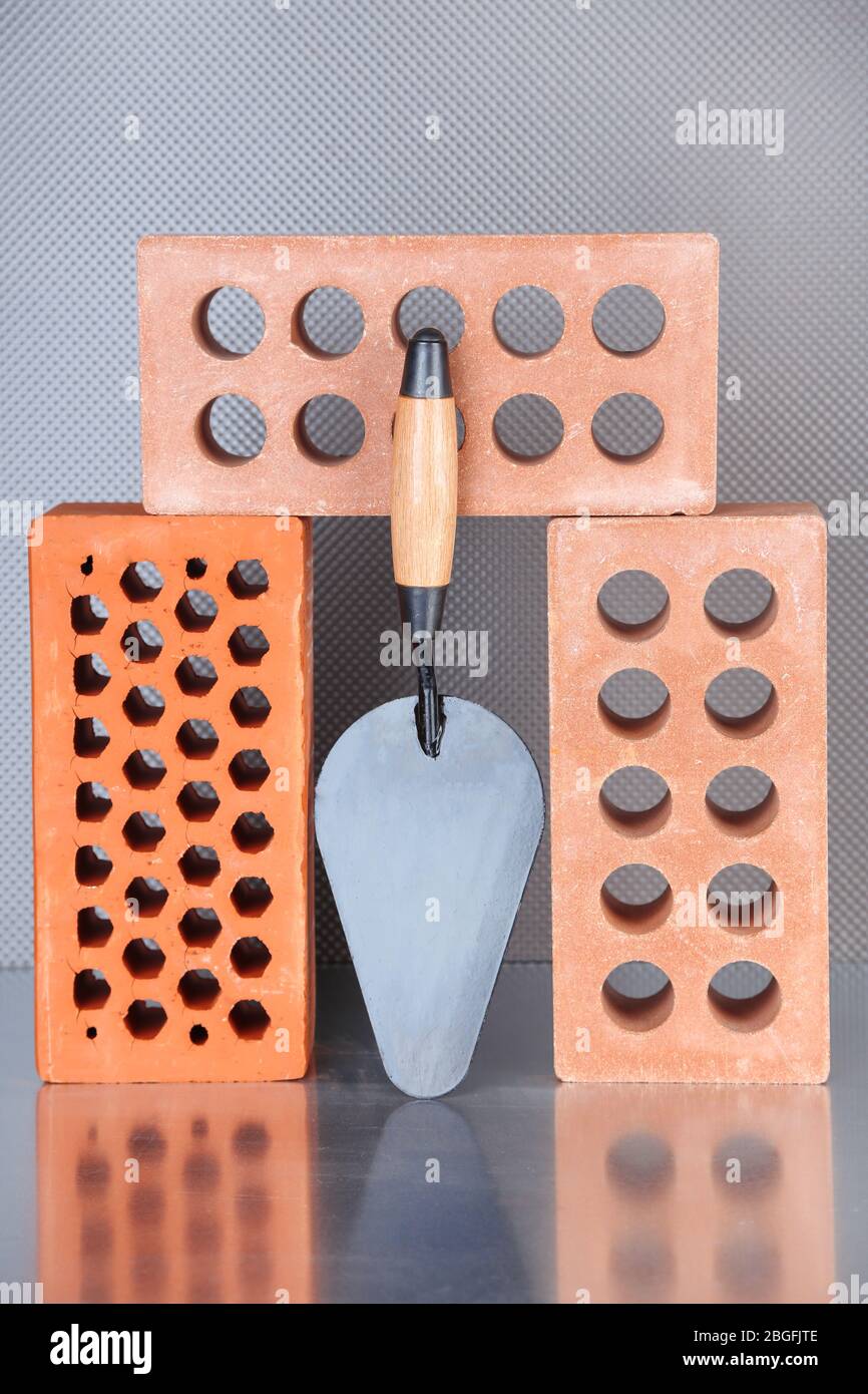 Metal tool for building and bricks on bright background Stock Photo - Alamy