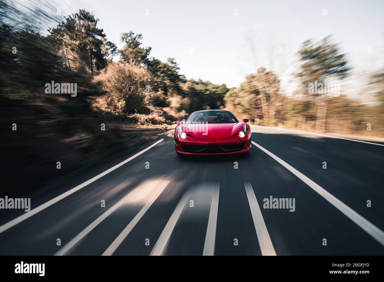 Red color racecar in the sunset drive in the forest,front view Stock ...