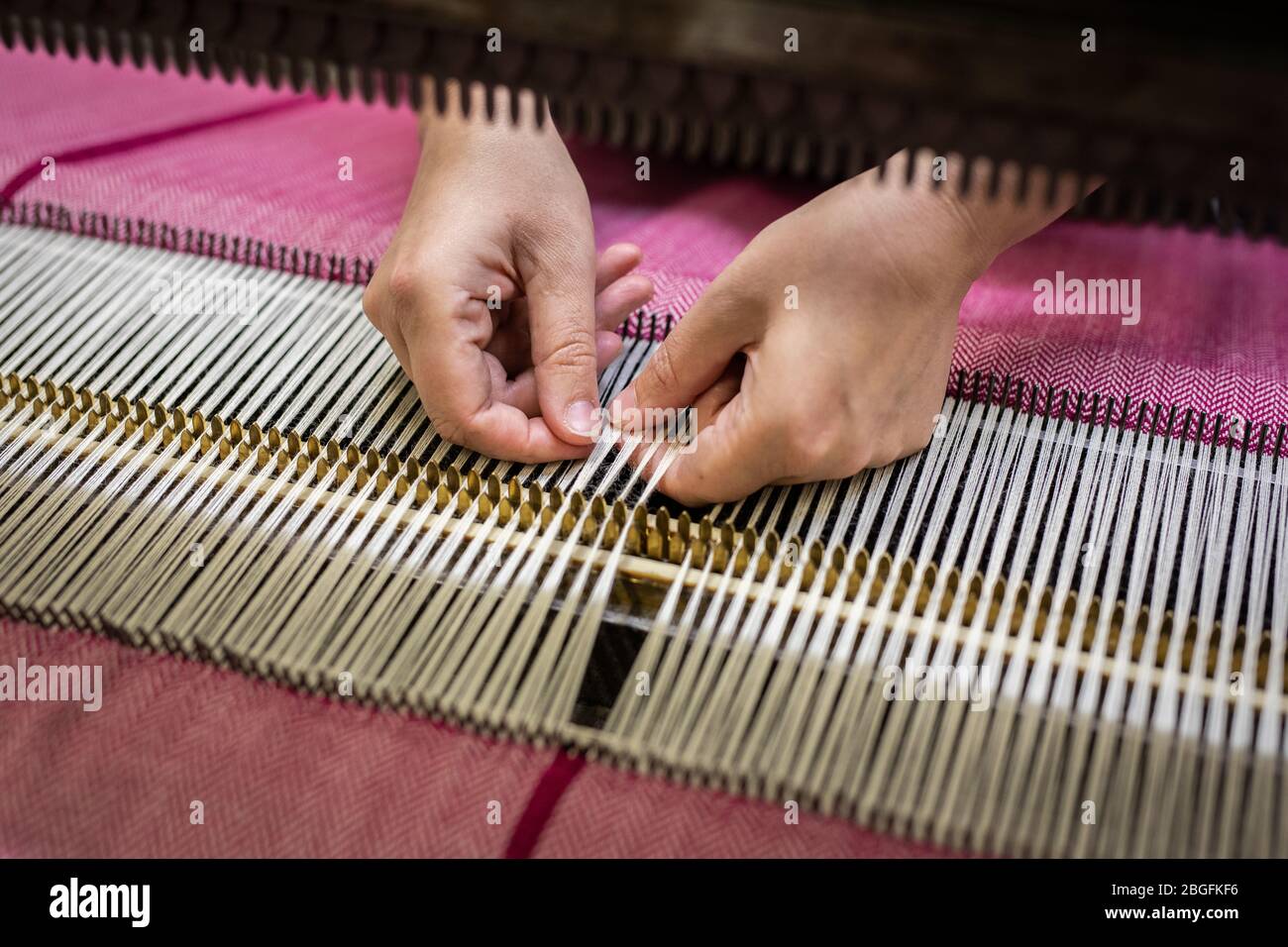 Hands pulling threads in a textile factory Stock Photo - Alamy