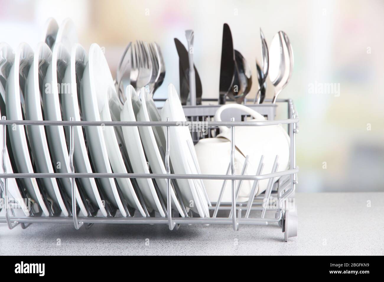 Clean dishes drying on metal dish rack on light background Stock Photo ...