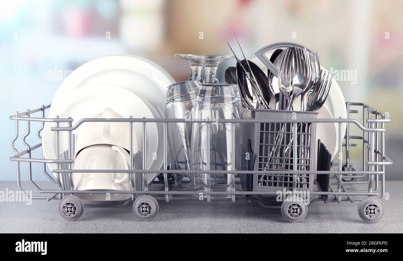 Clean dishes drying on metal dish rack on light background Stock Photo ...
