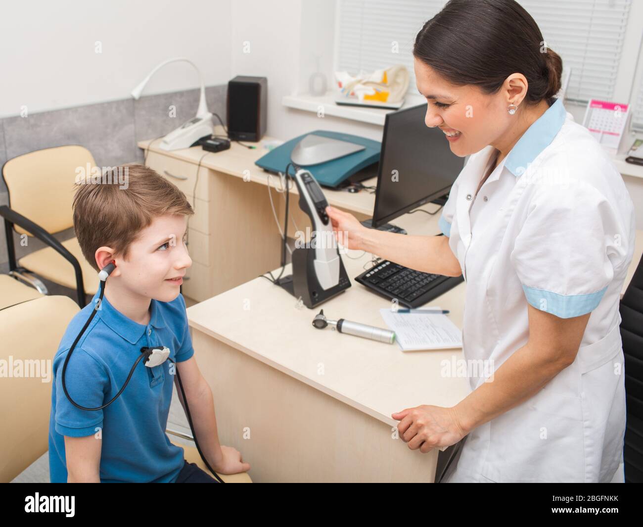 Audiologist woman is doing a hearing exam on a boy. Impedance ...