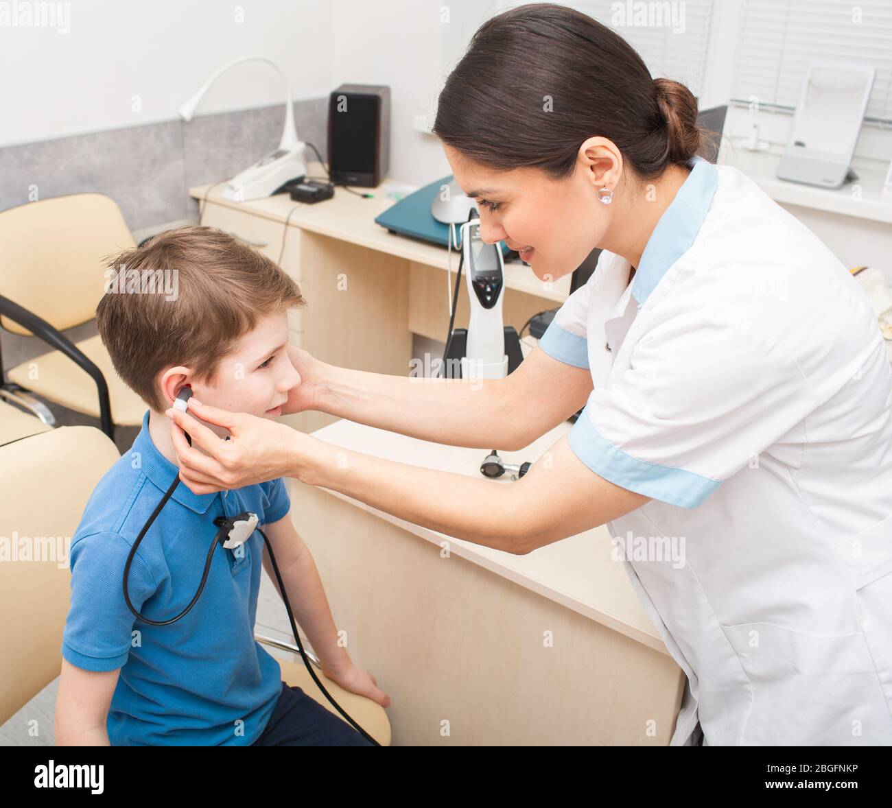 Audiologist woman is doing a hearing exam on a boy. Impedance ...