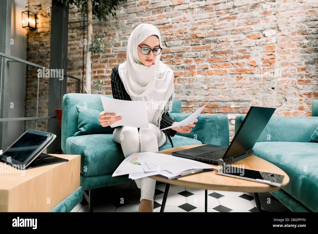 Beautiful concentrated muslim business woman, working with financial ...