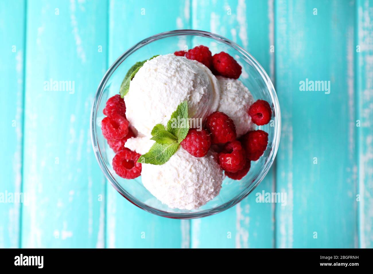 Creamy ice cream with raspberries on plate in glass bowl, on color ...