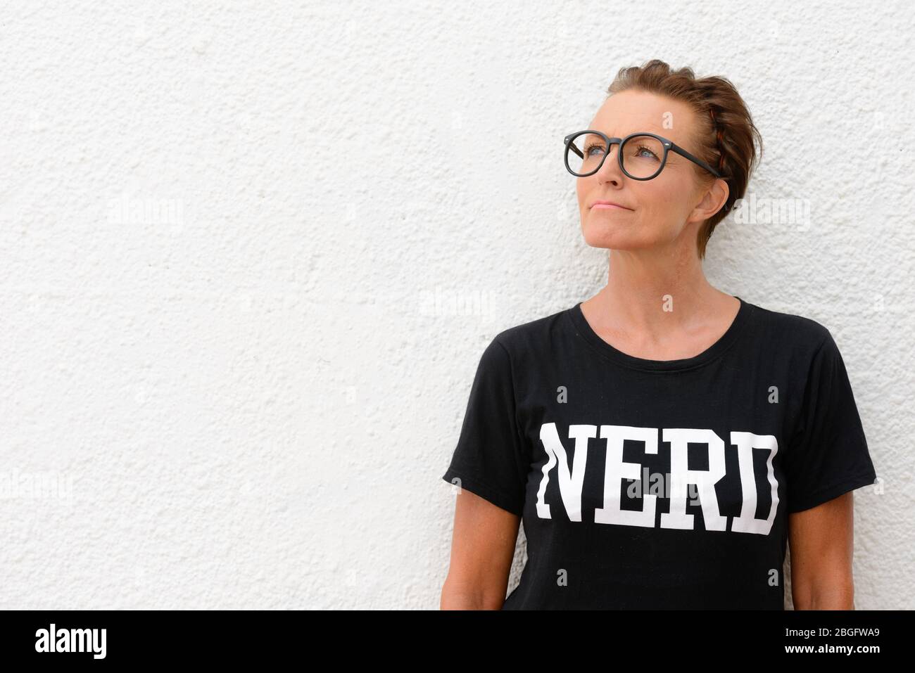 Mature nerd woman wearing big eyeglasses and standing against white ...