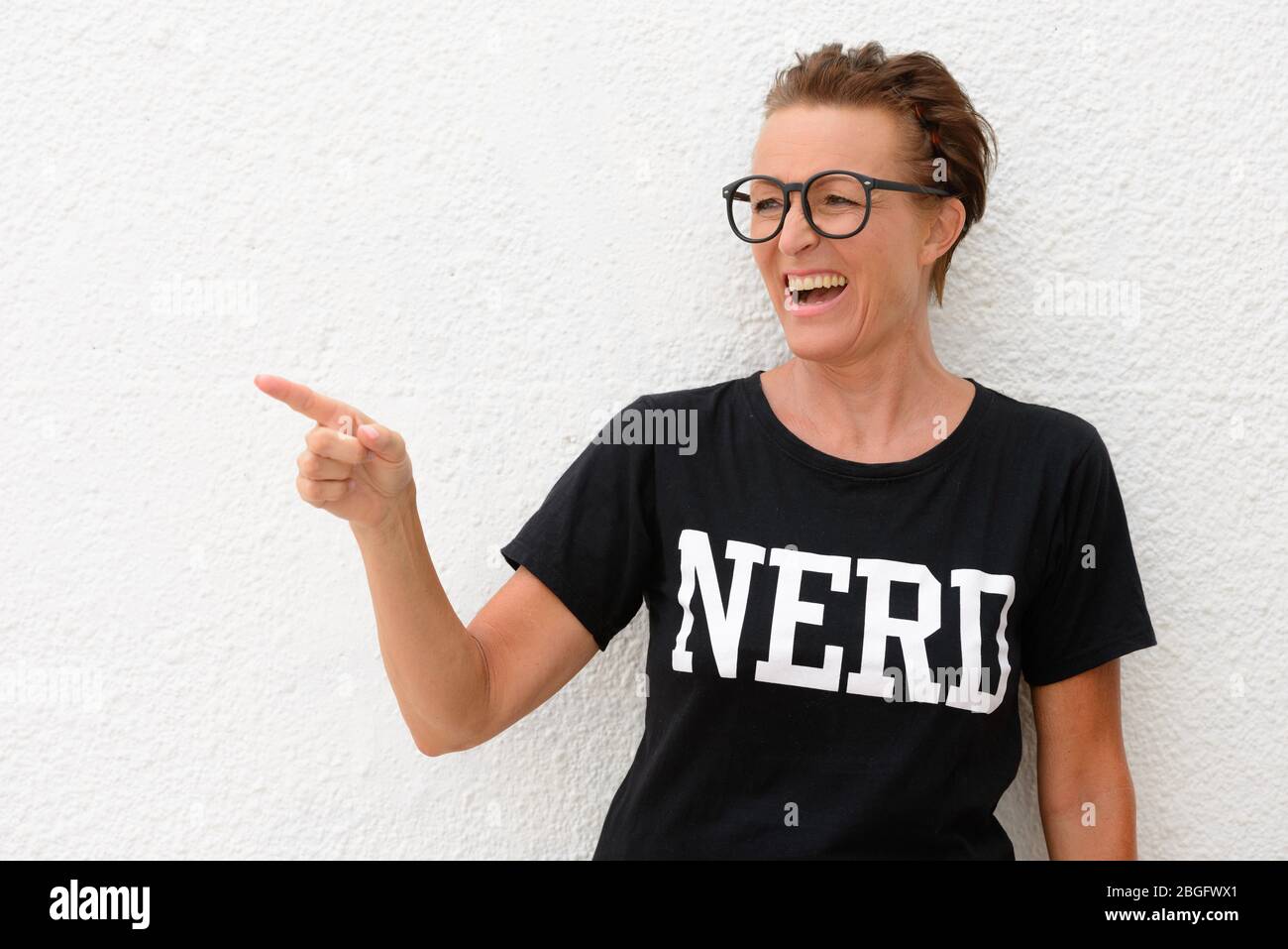 Mature nerd woman wearing big eyeglasses and standing against white ...