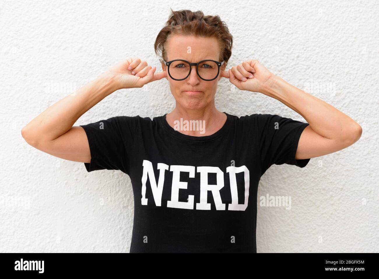 Mature nerd woman wearing big eyeglasses and standing against white ...