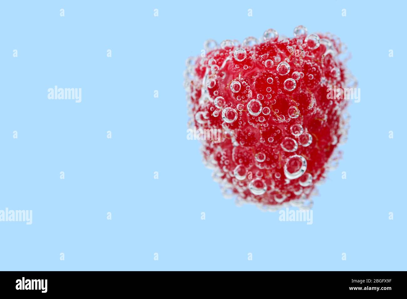 Beautiful raspberry in water with bubbles, on blue background Stock ...