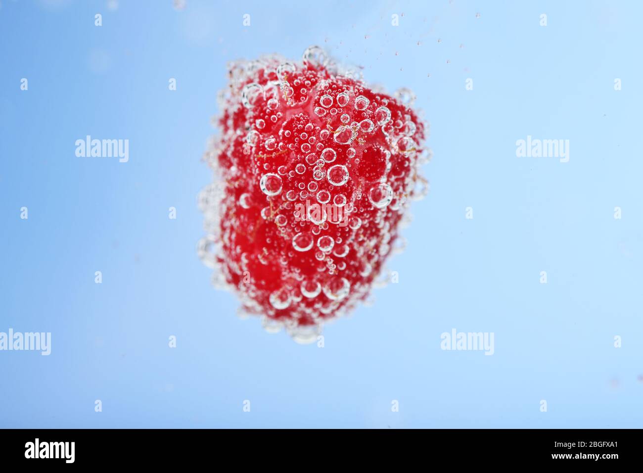 Beautiful raspberry in water with bubbles, on blue background Stock ...