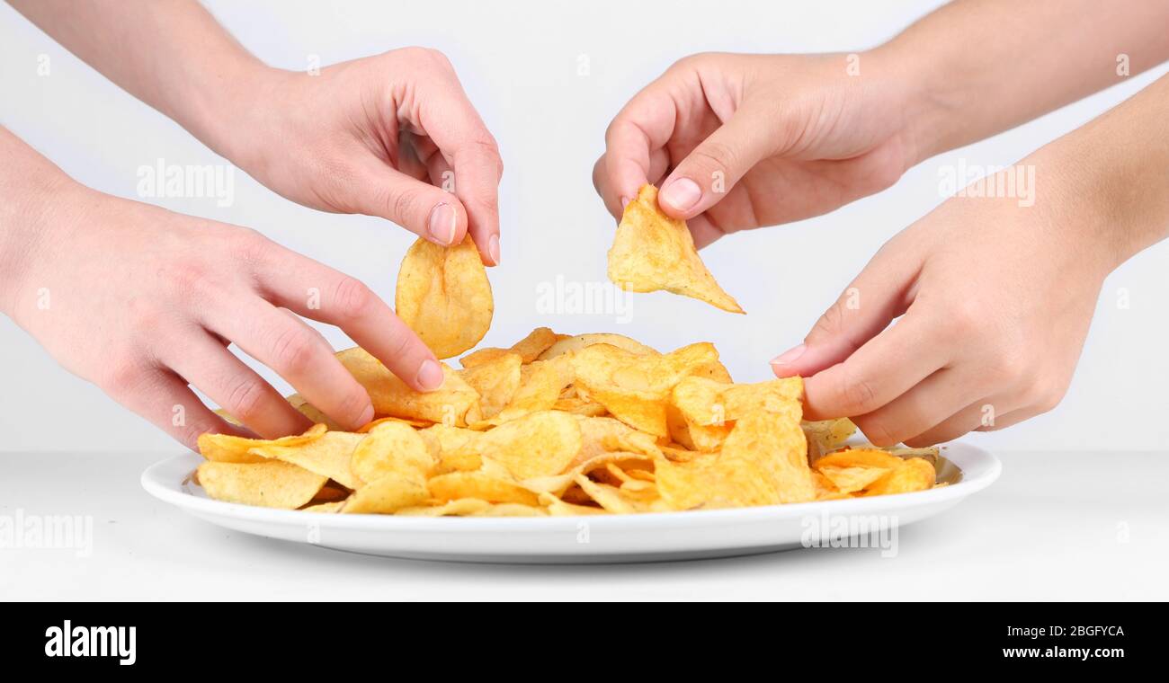 Hands of people take chips from bowl Stock Photo - Alamy