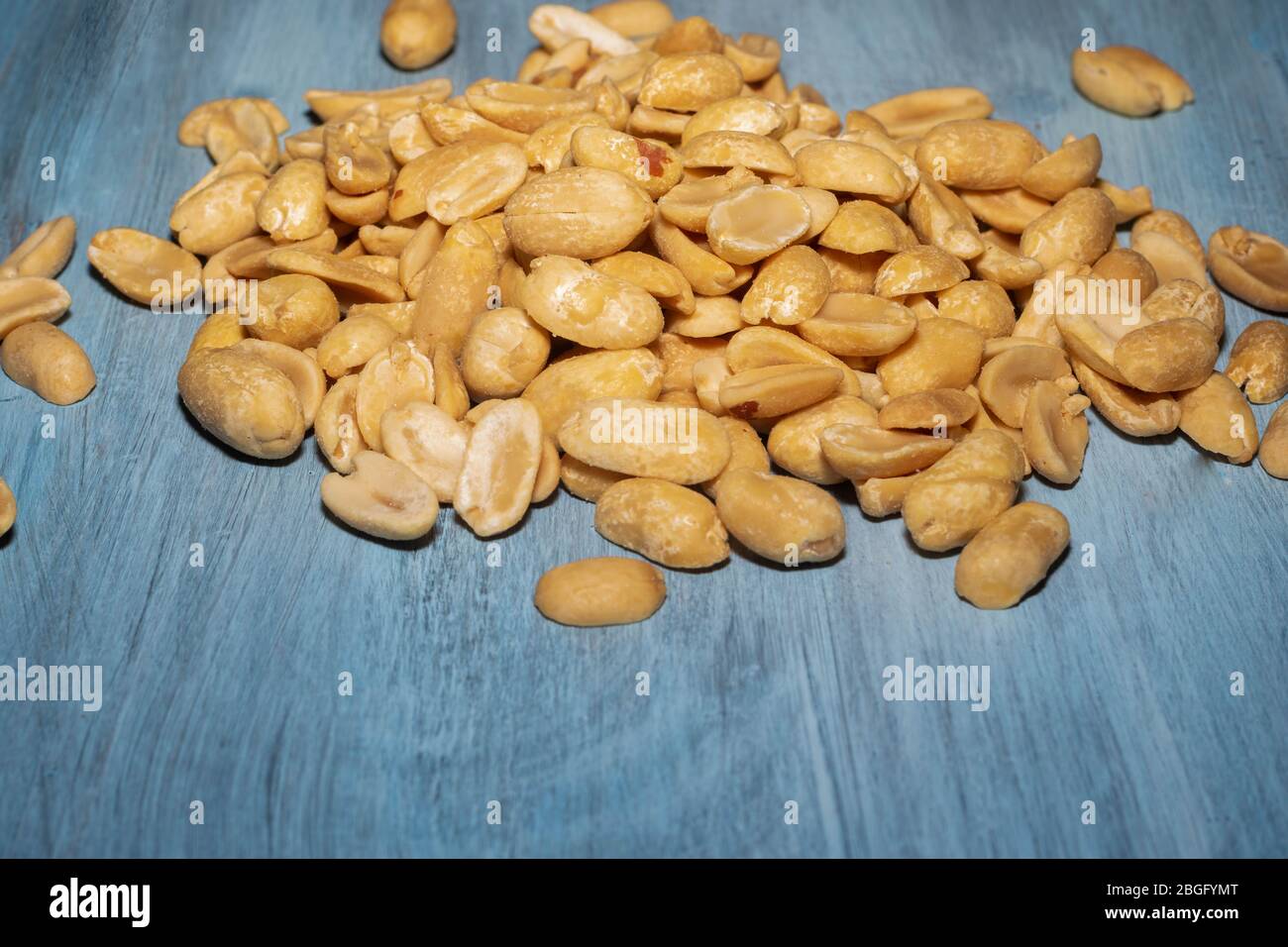 many peeled peanuts on blue color background Stock Photo - Alamy