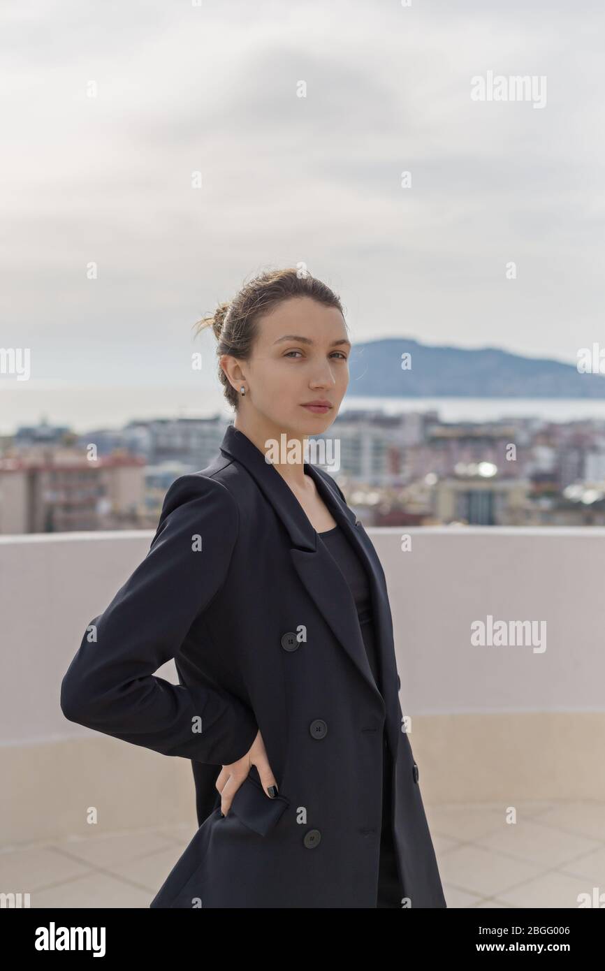 Self-confident business woman wearing elegant black suit Stock Photo ...