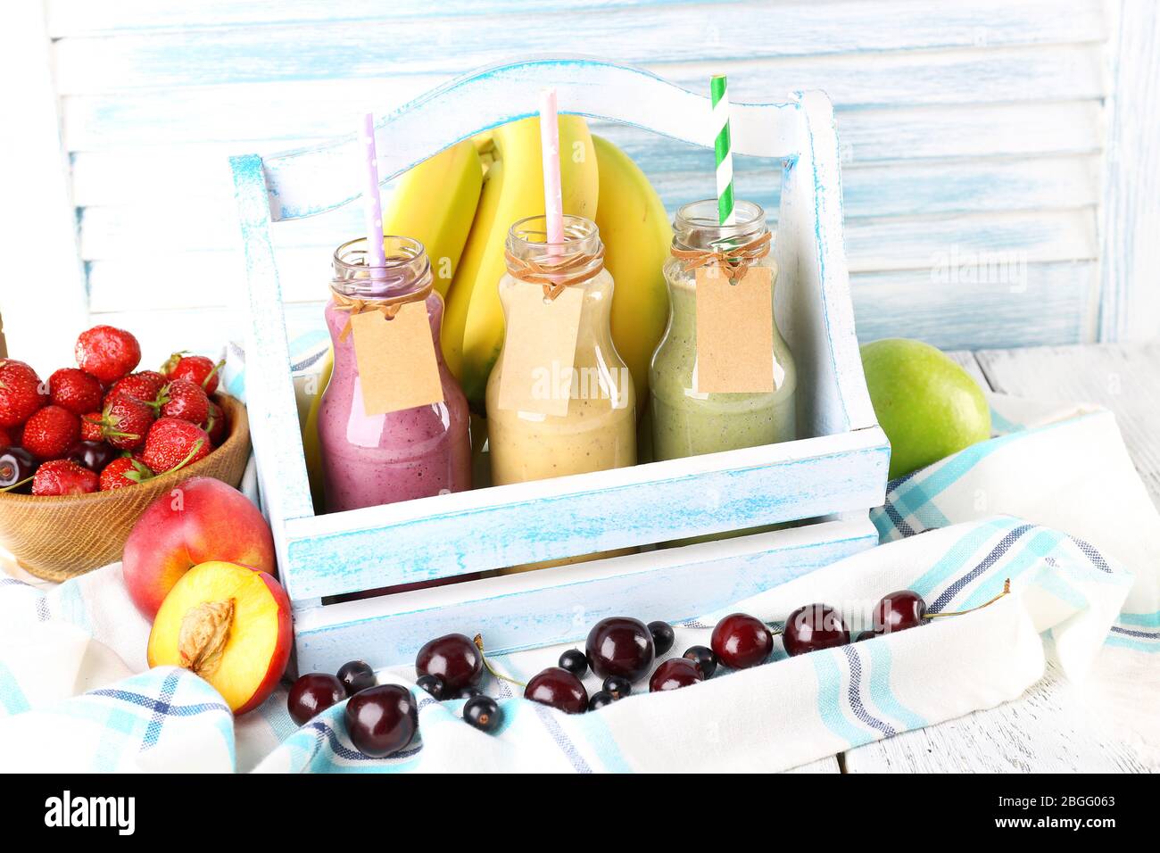 Bottles of delicious smoothie in wooden basket on table, close-up Stock ...