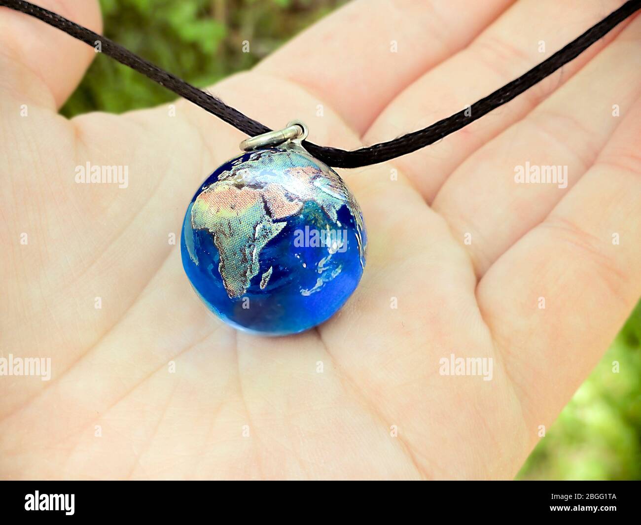 Earth Necklace in a Person's Hand Stock Photo - Alamy