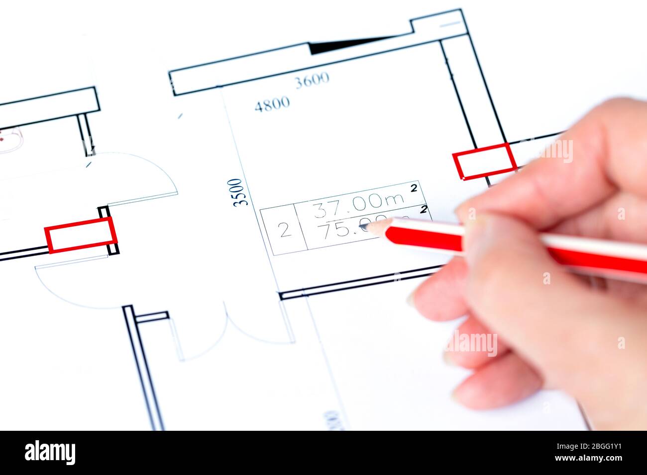 Macro close up of quantity surveyors hand reviewing technical drawing ...