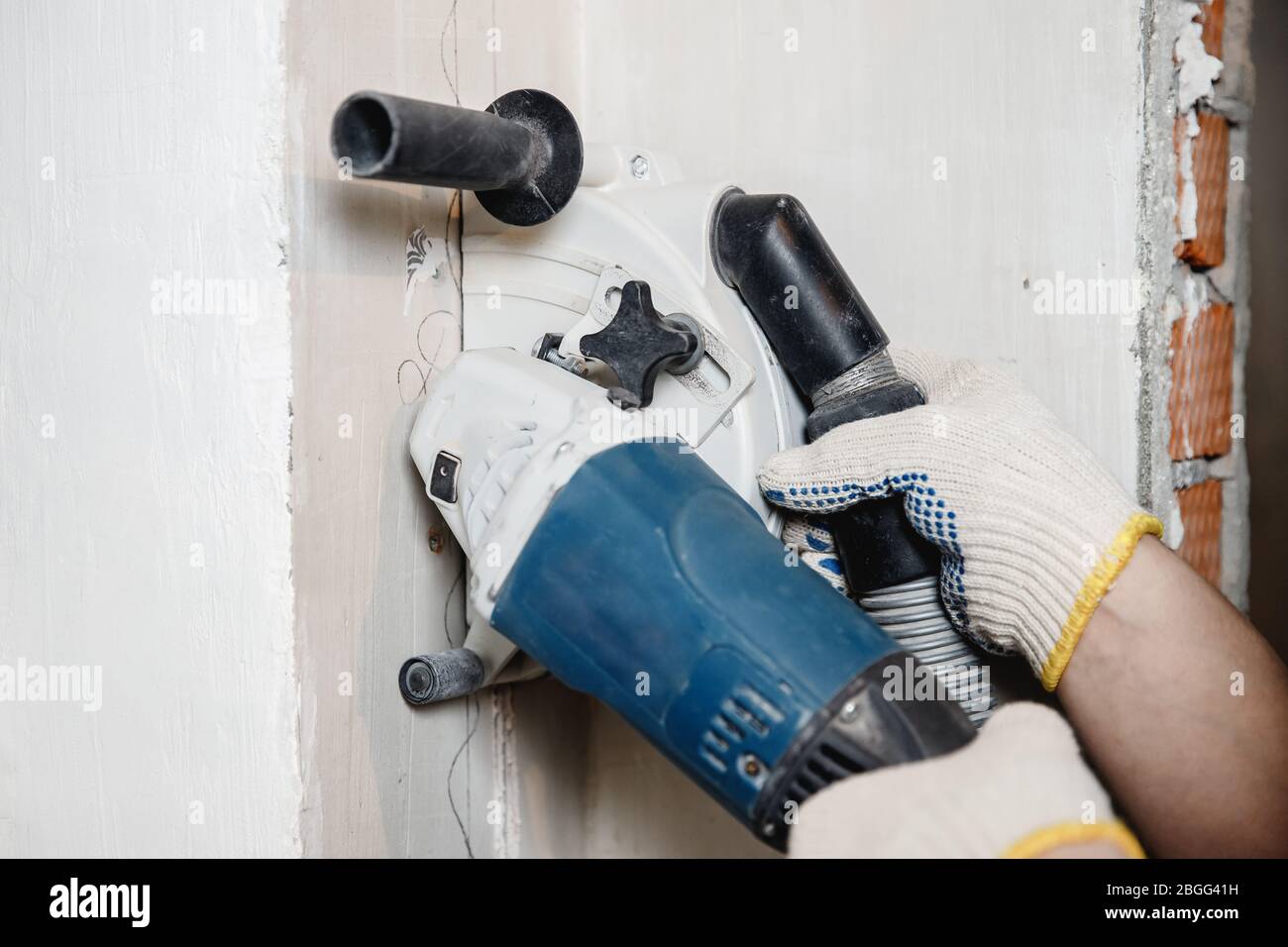 Builder man cutting electrical chase in concrete wall with groove ...