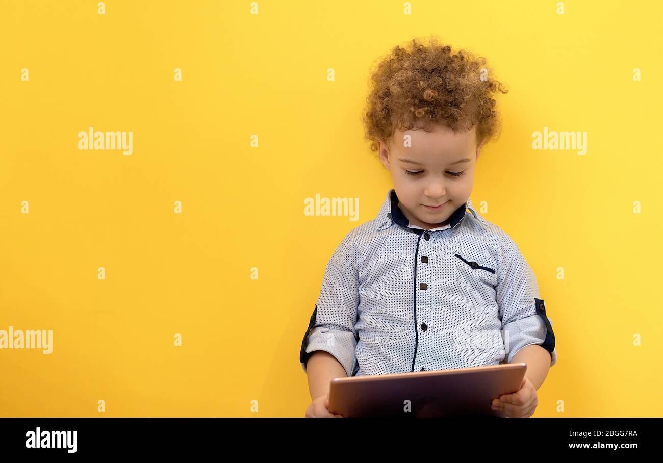 Kids home quarantine. Hesitant crazy little curly boy that looks the ...