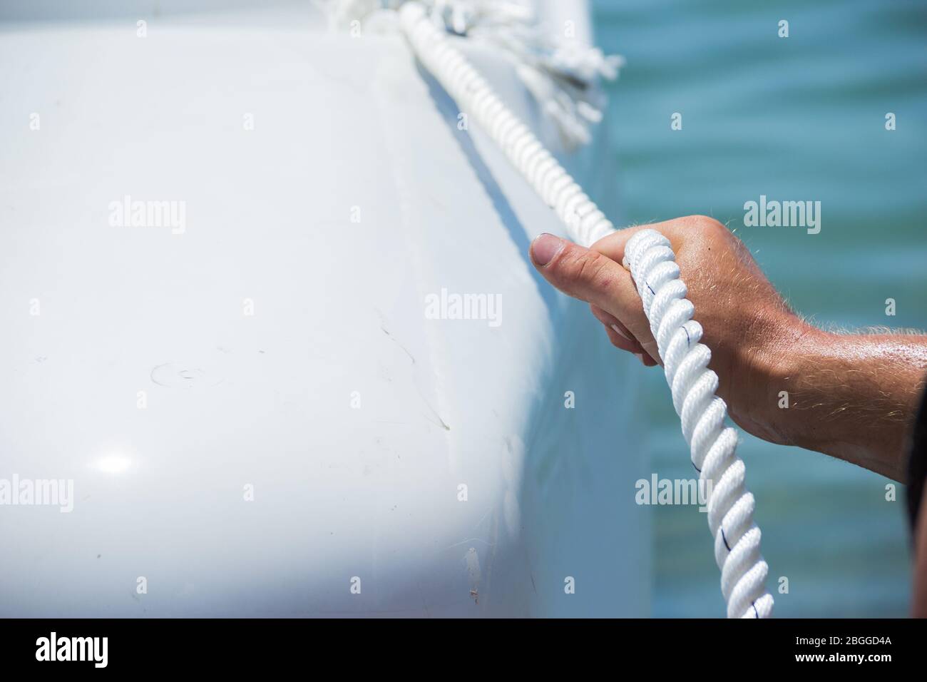 men's hands tied the rope on the yacht Stock Photo - Alamy