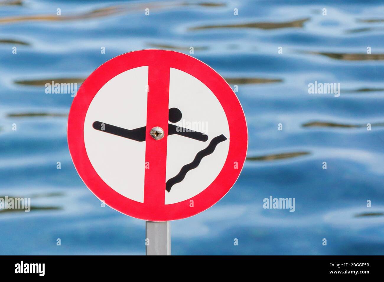 No diving or jumping sign on the blue water background Stock Photo - Alamy