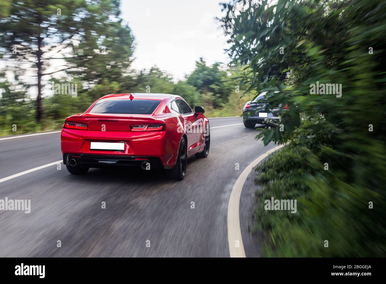 Red and black sport cars passing each other in landscapes Stock Photo ...