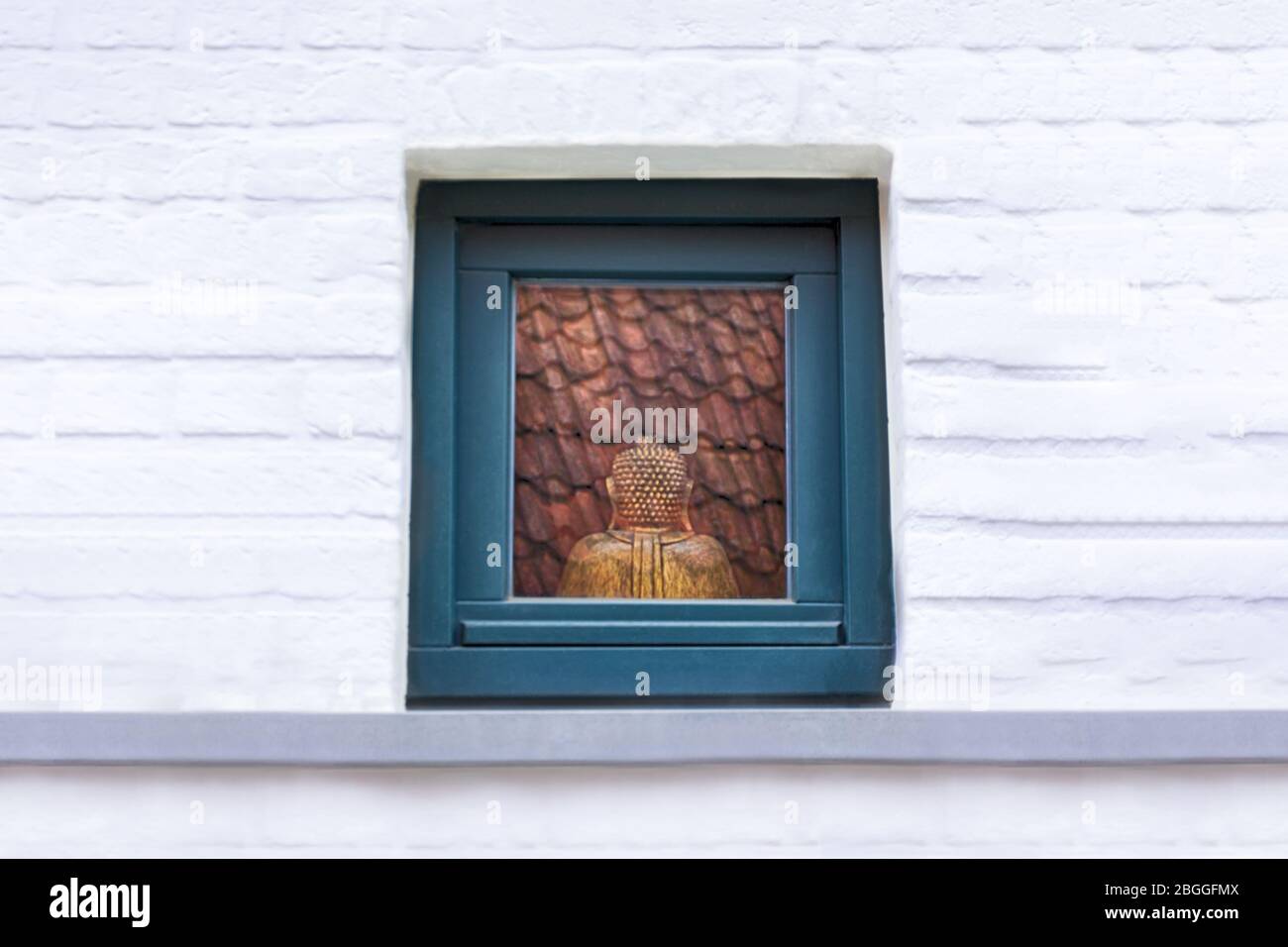 Buddha statue in the window. Bronze Buddha sitting back. Copy space ...