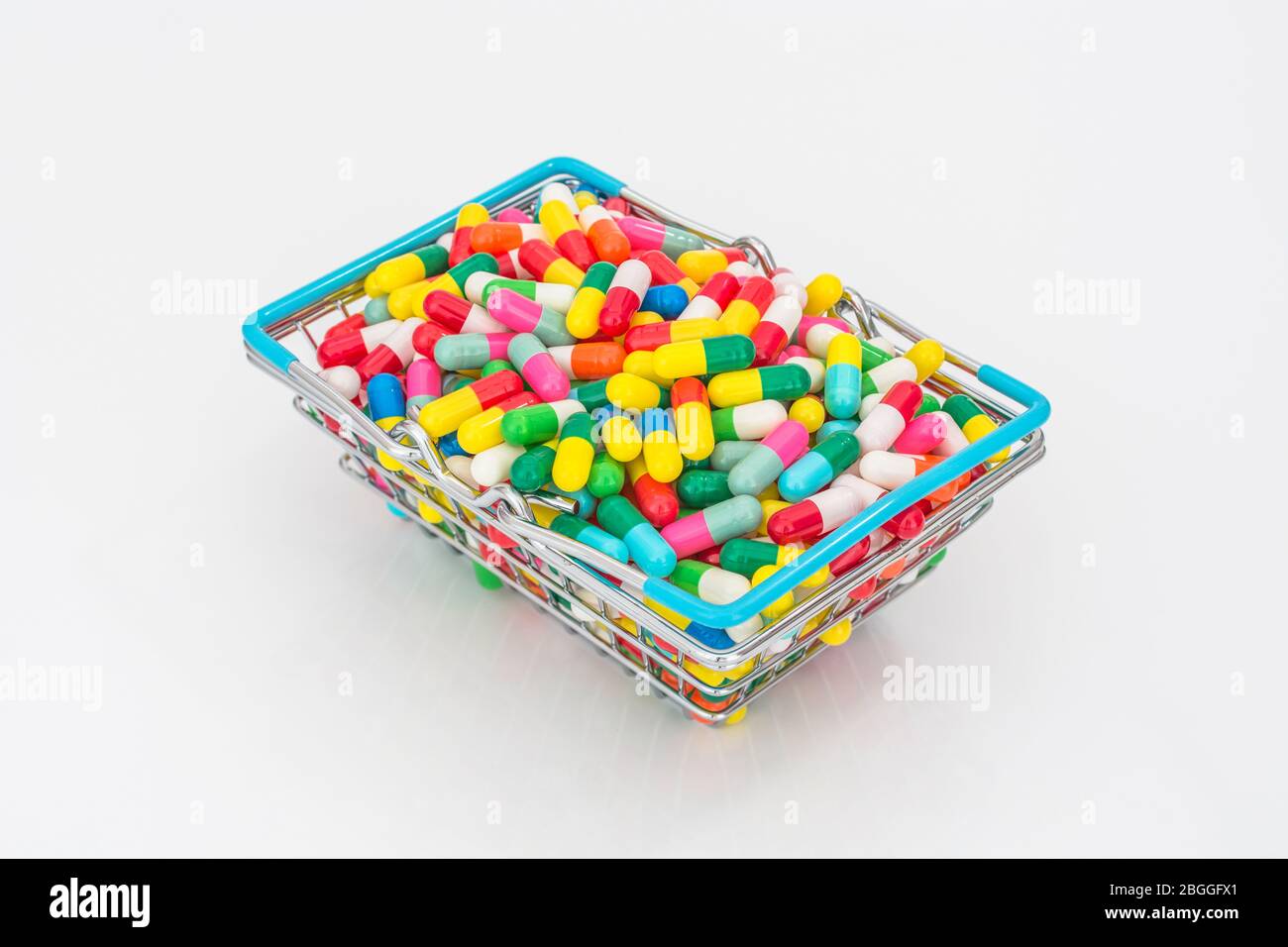 Mini shopping basket full of colourful pills caplets. For Big Pharma ...